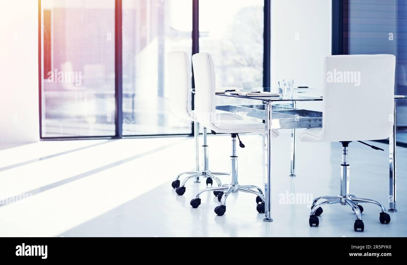 Design your office for success. an empty boardroom furnished with a table and chairs Stock Photo ...
