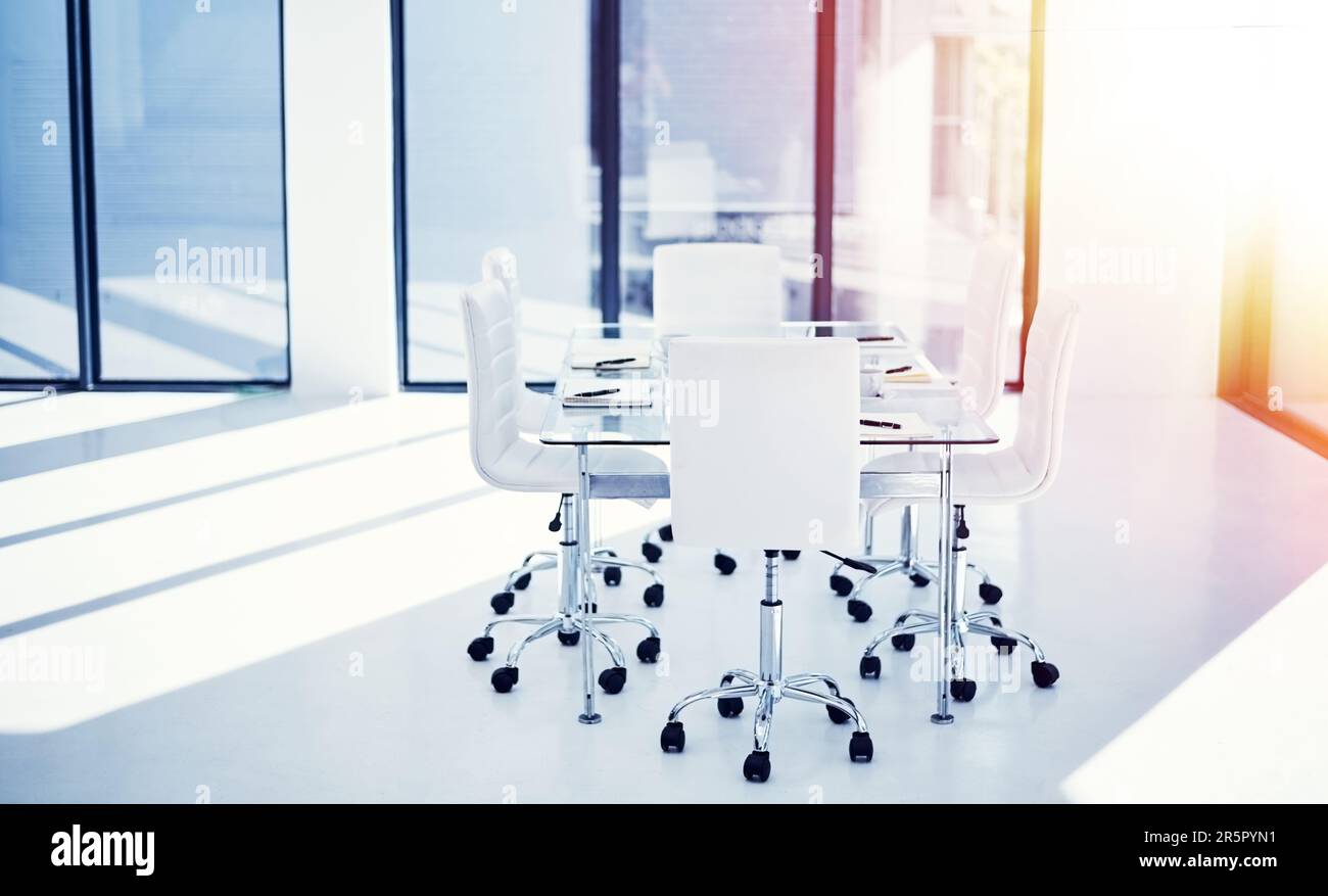 Create a unique image for your business. an empty boardroom furnished with a table and chairs ...