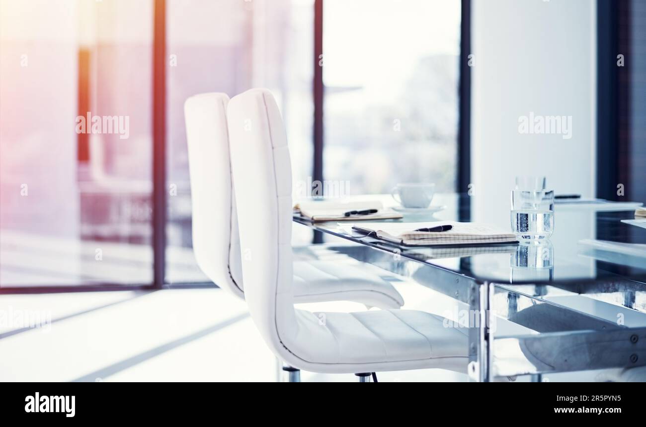 Set yourself up for success. an empty boardroom furnished with a table and chairs Stock Photo ...