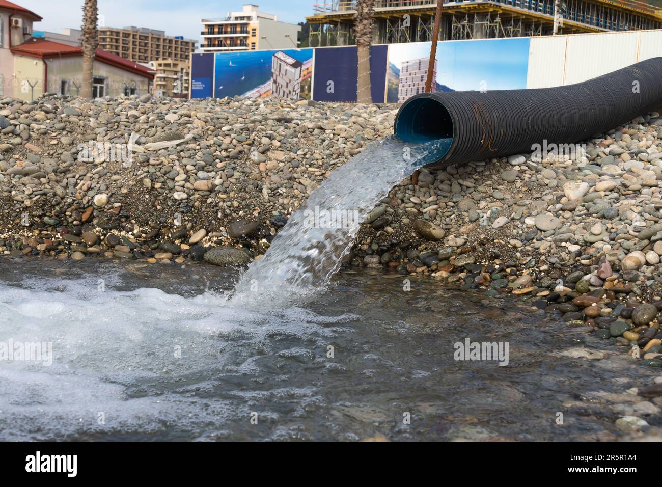 Close-up of a large plastic water pipe with a large stream of water ...