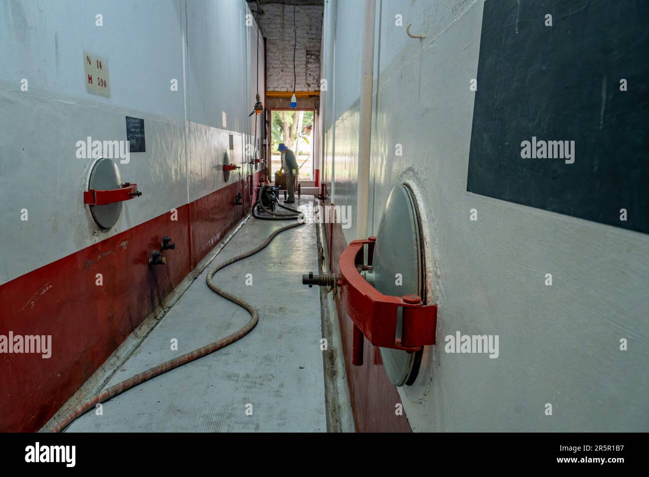 A worker circulates fermenting wine with a pump at La Abeja Winery in ...