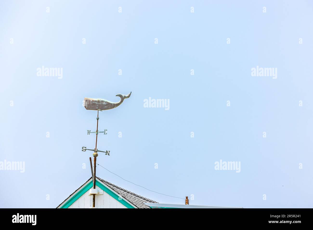 An old weather vane in the shape of a whale on a roof top Stock Photo ...