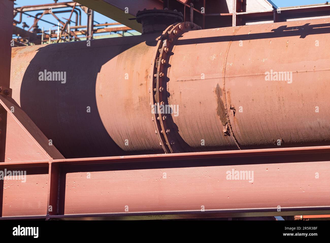 A steel staircase with a handrail winding upwards along a metal pipe ...
