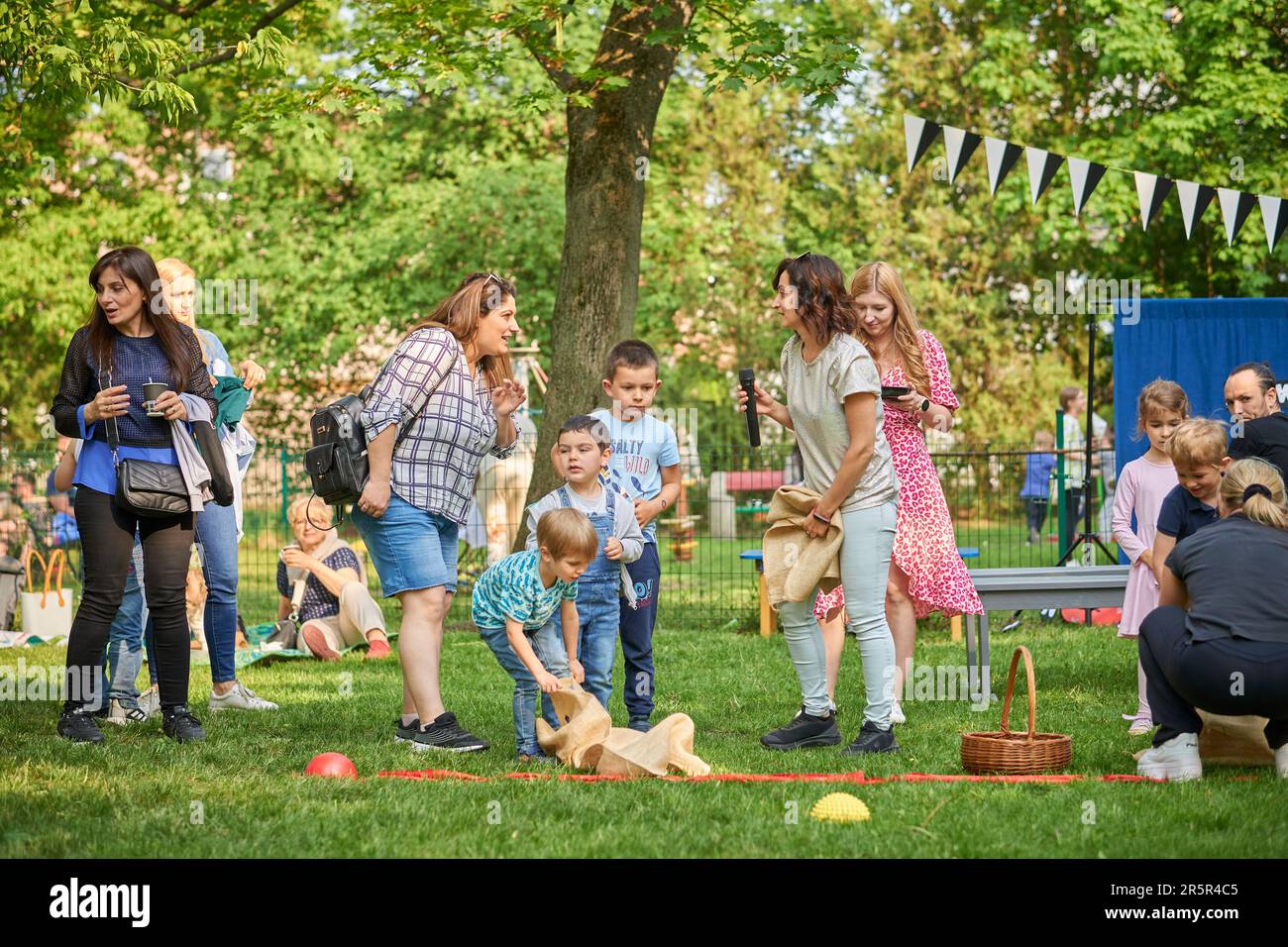 A group of diverse children playing and laughing together in a park ...