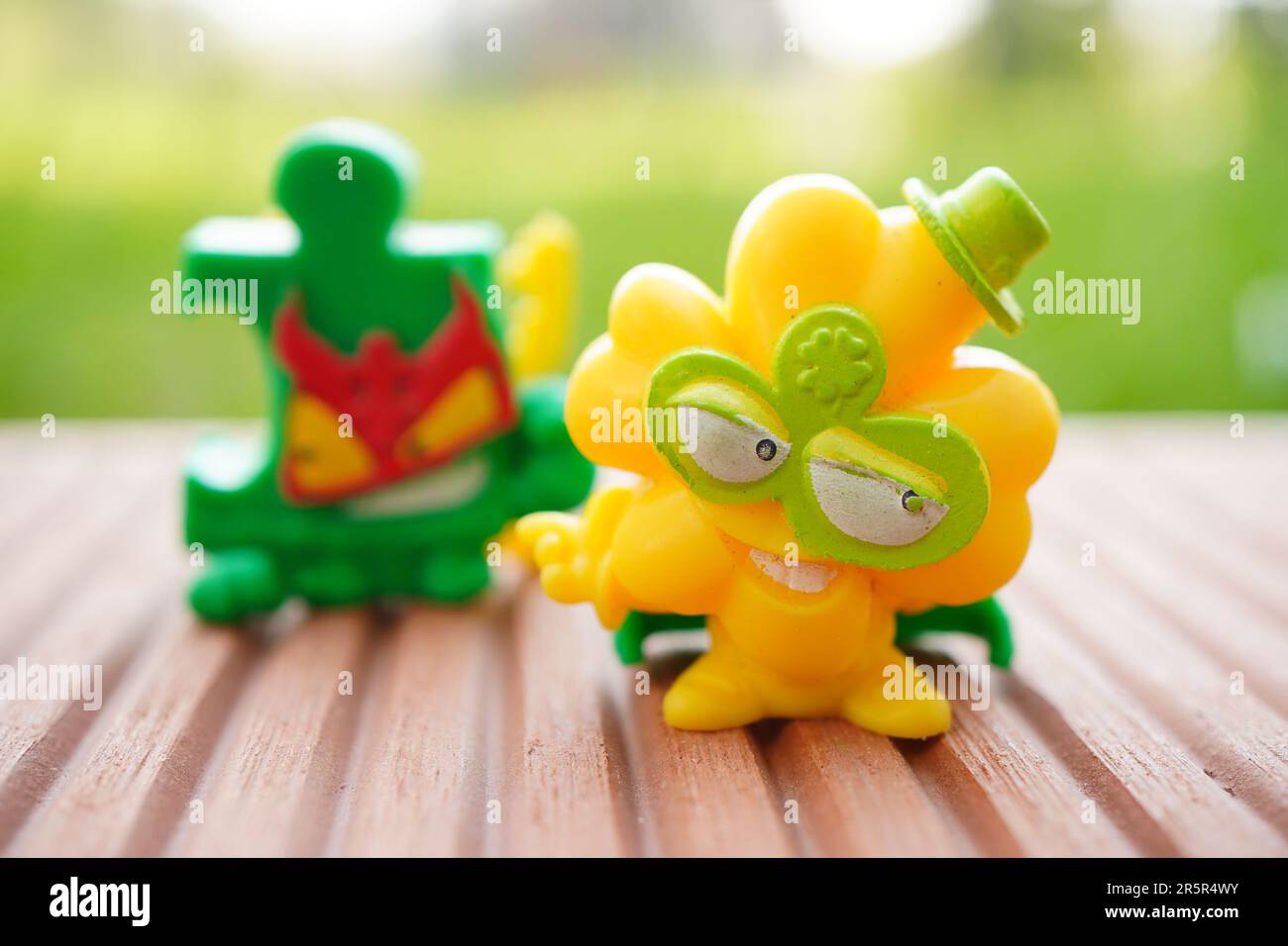 Two plastic toy figures illuminated by a green light are placed on a ...