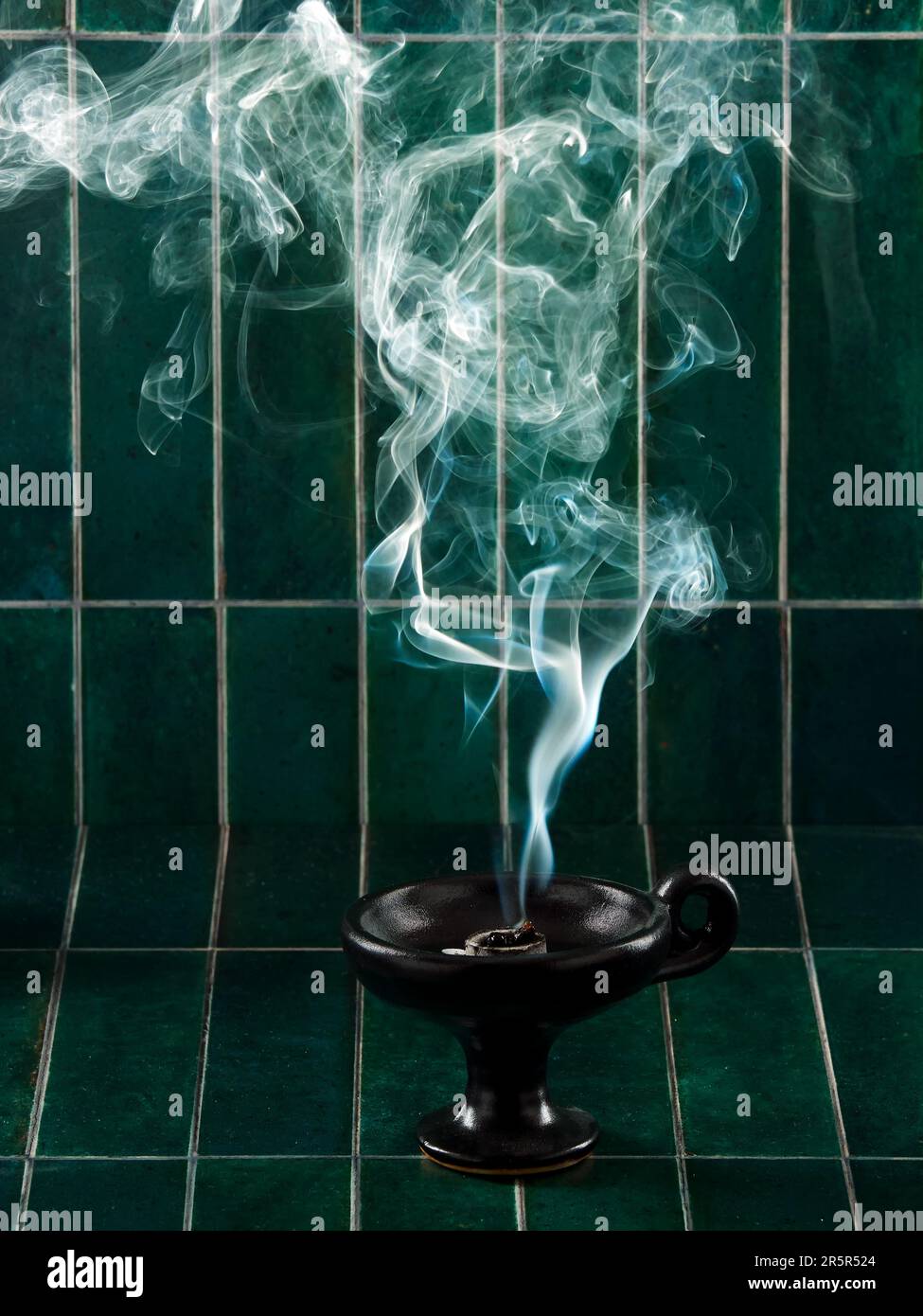 Ceremonial Orthodox incense smoke ascending from black censer, on green tiles background Stock ...