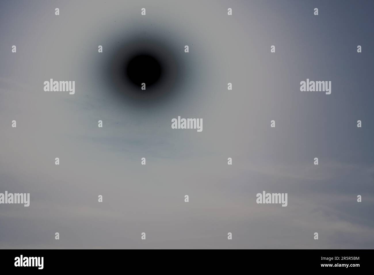 A black hole instead of the sun in the smoky daytime sky, solar eclipse ...