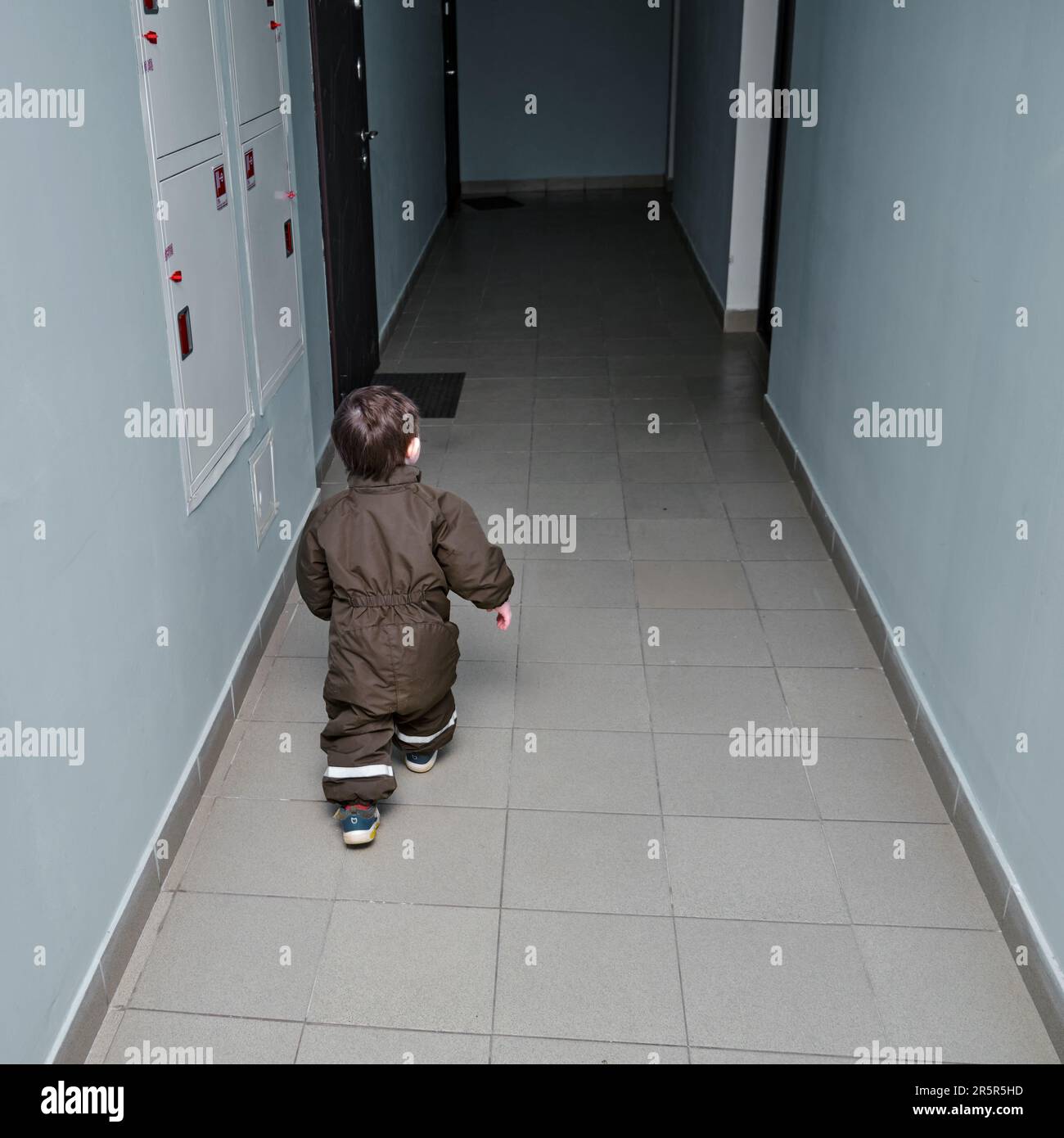 A child walks down the corridor of an apartment building. Baby comes ...