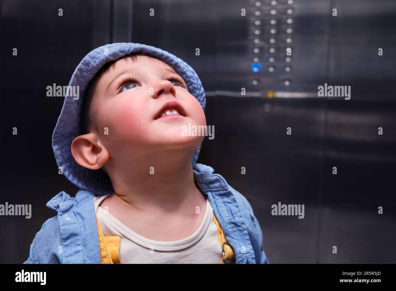 Happy baby rides in the elevator of an apartment building with buttons ...