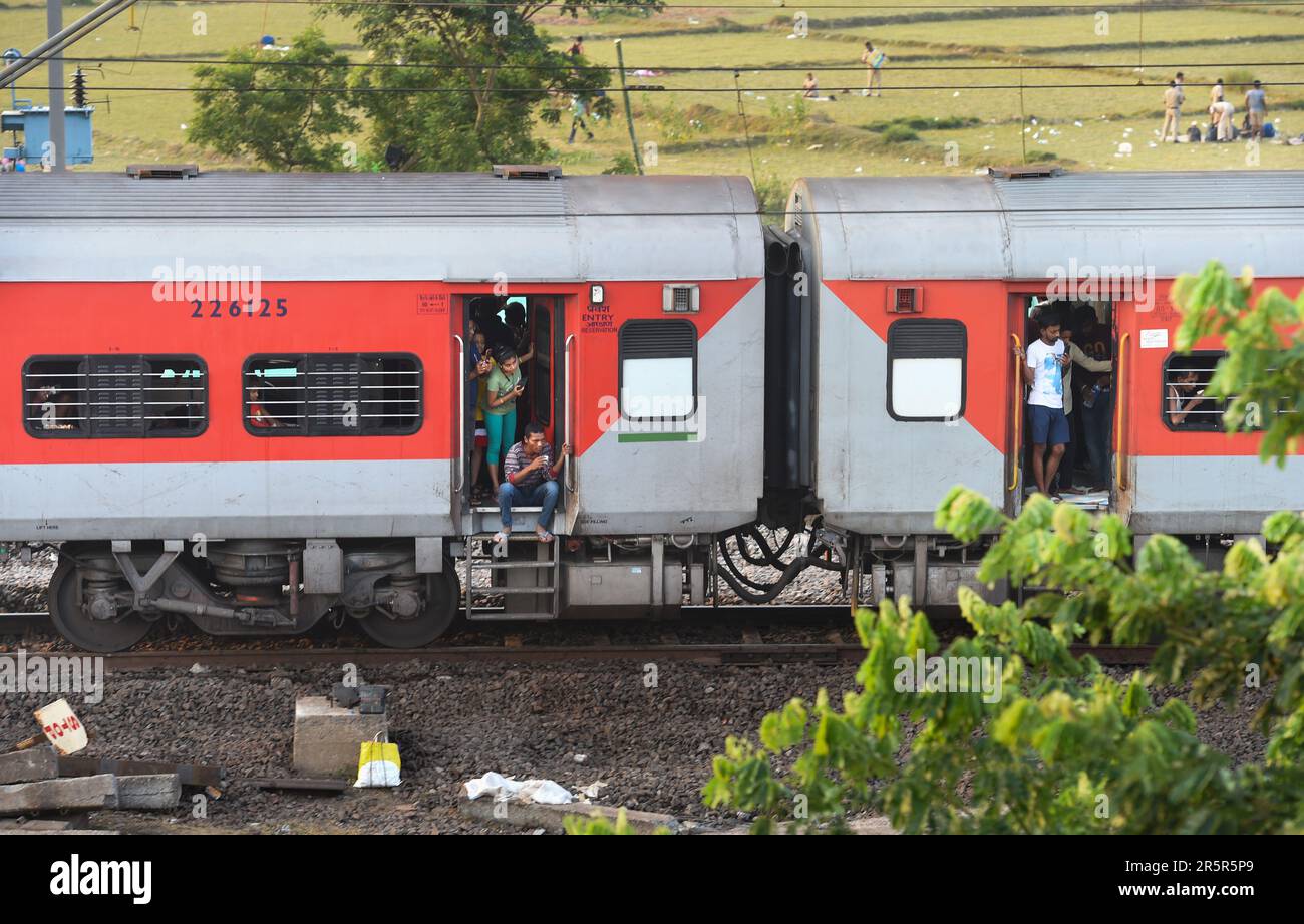 Balasore. 5th June, 2023. A passenger train passes by the site of a ...