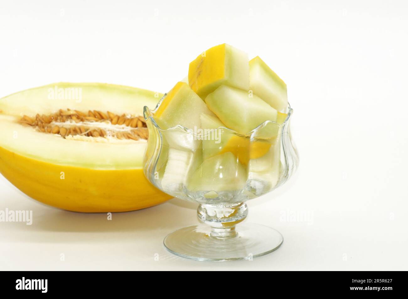 A clear glass filled with a variety of fresh, ripe fruit, including a ...