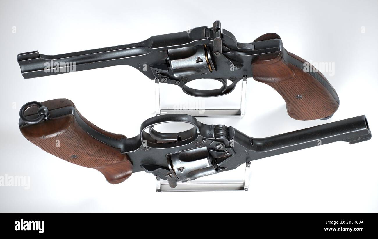 The two vintage revolvers on metallic stands against a white backdrop ...