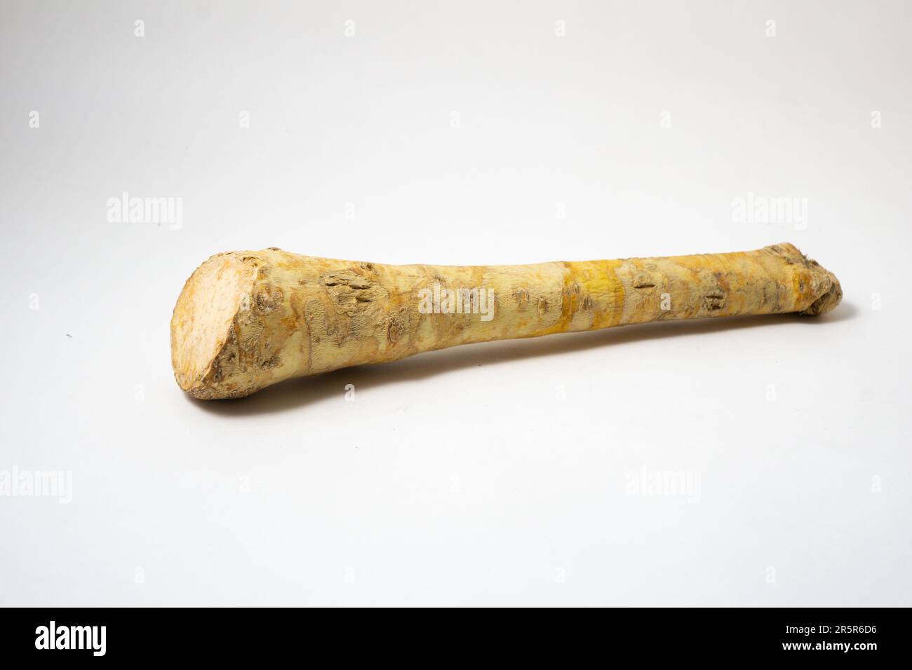 A close-up image of a raw carrot root without its skin, sitting on a ...