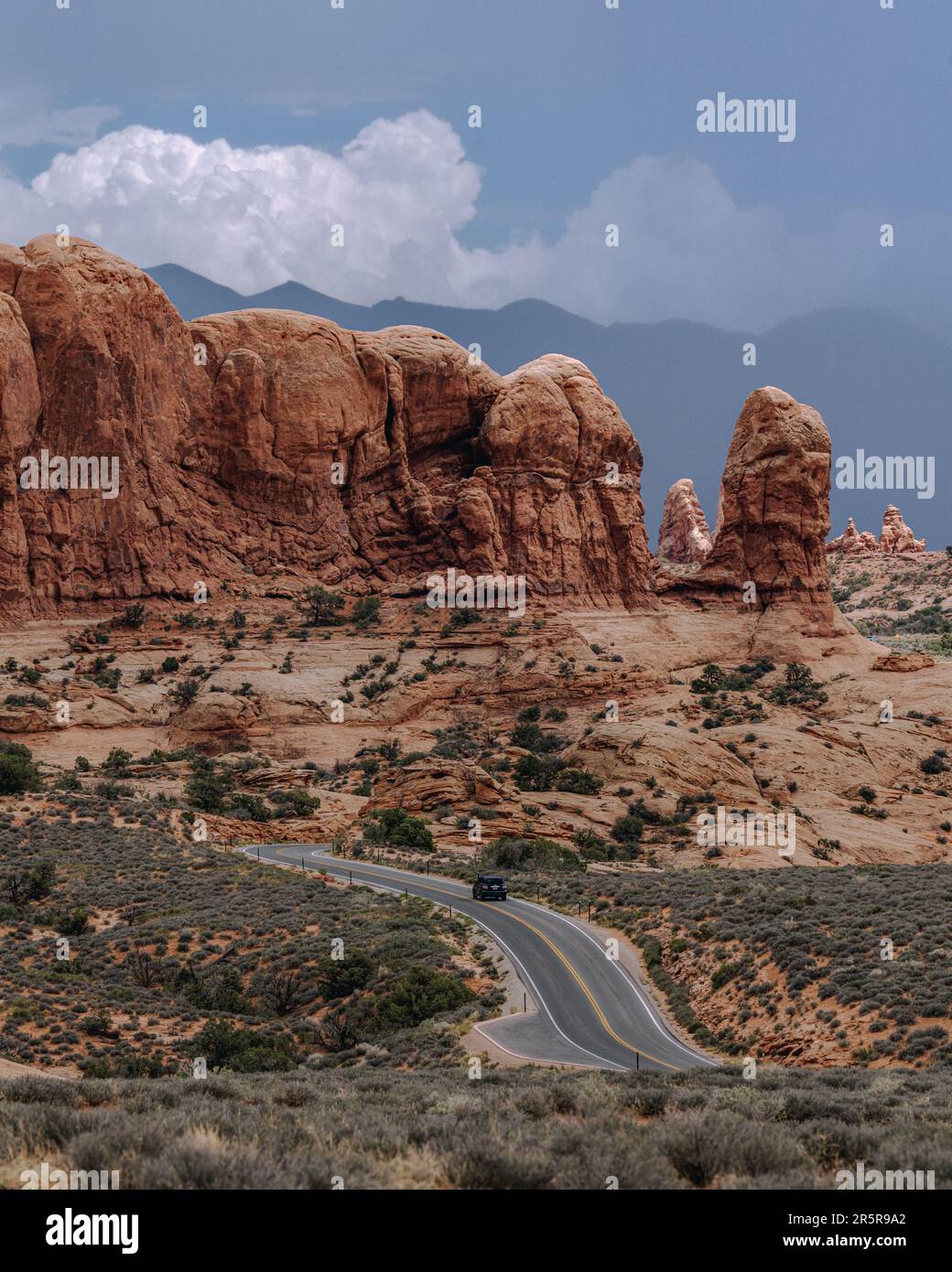 A stretch of desert highway winding through an arid landscape of jagged ...