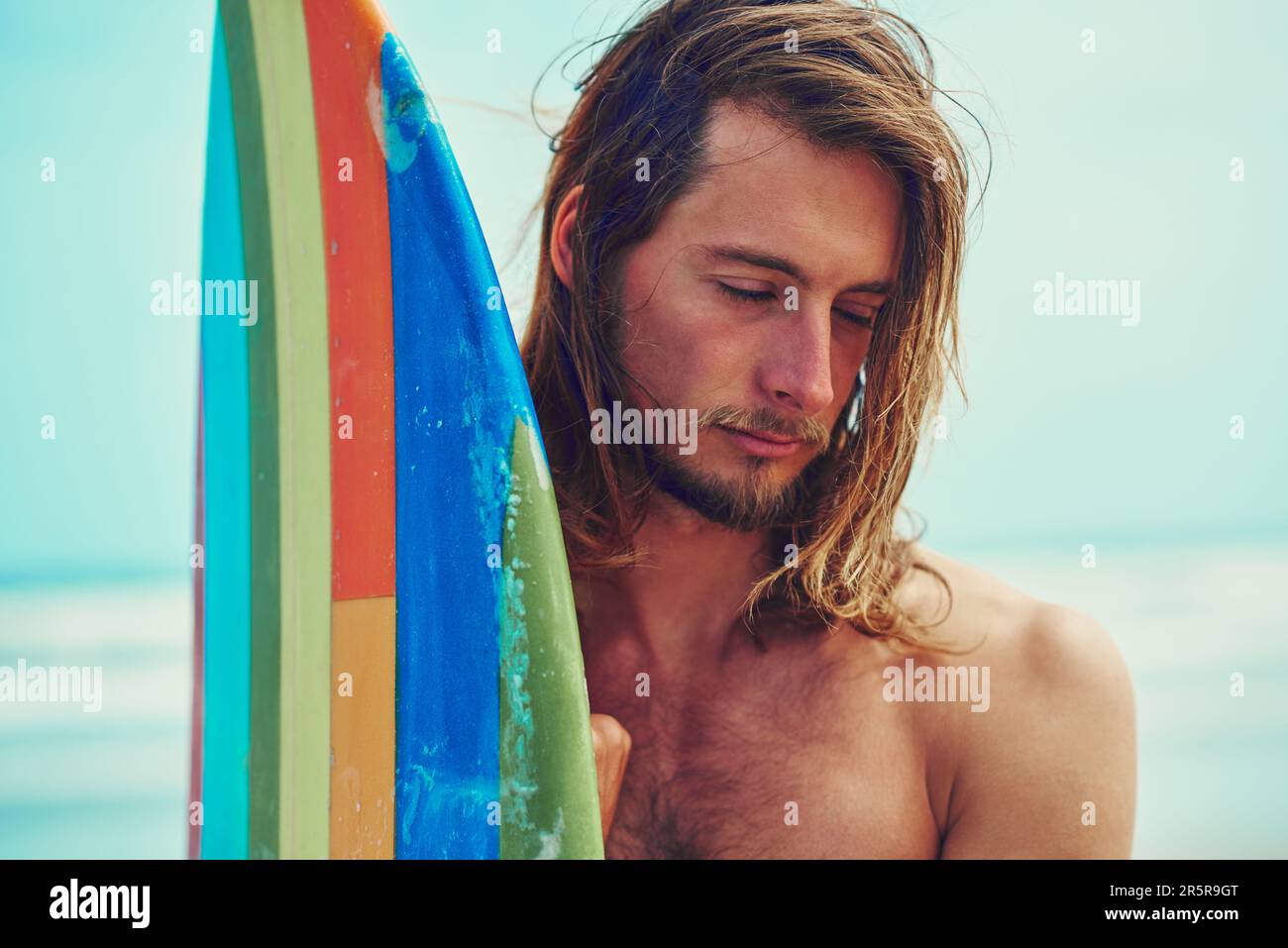 Surfing will make everything ok again. a young surfer leaning against ...