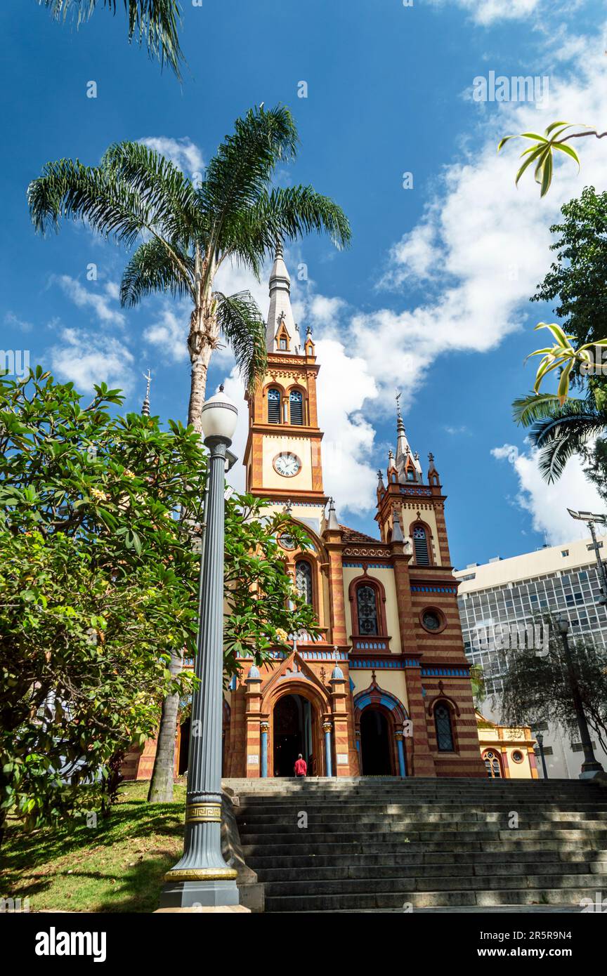 A beautiful stone church building surrounded by lush palm trees sits ...