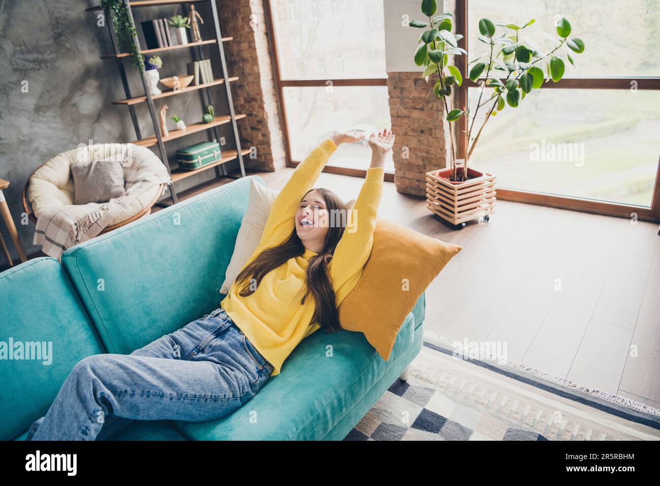 Photo of carefree overjoyed young person laying cozy couch stretch arms ...
