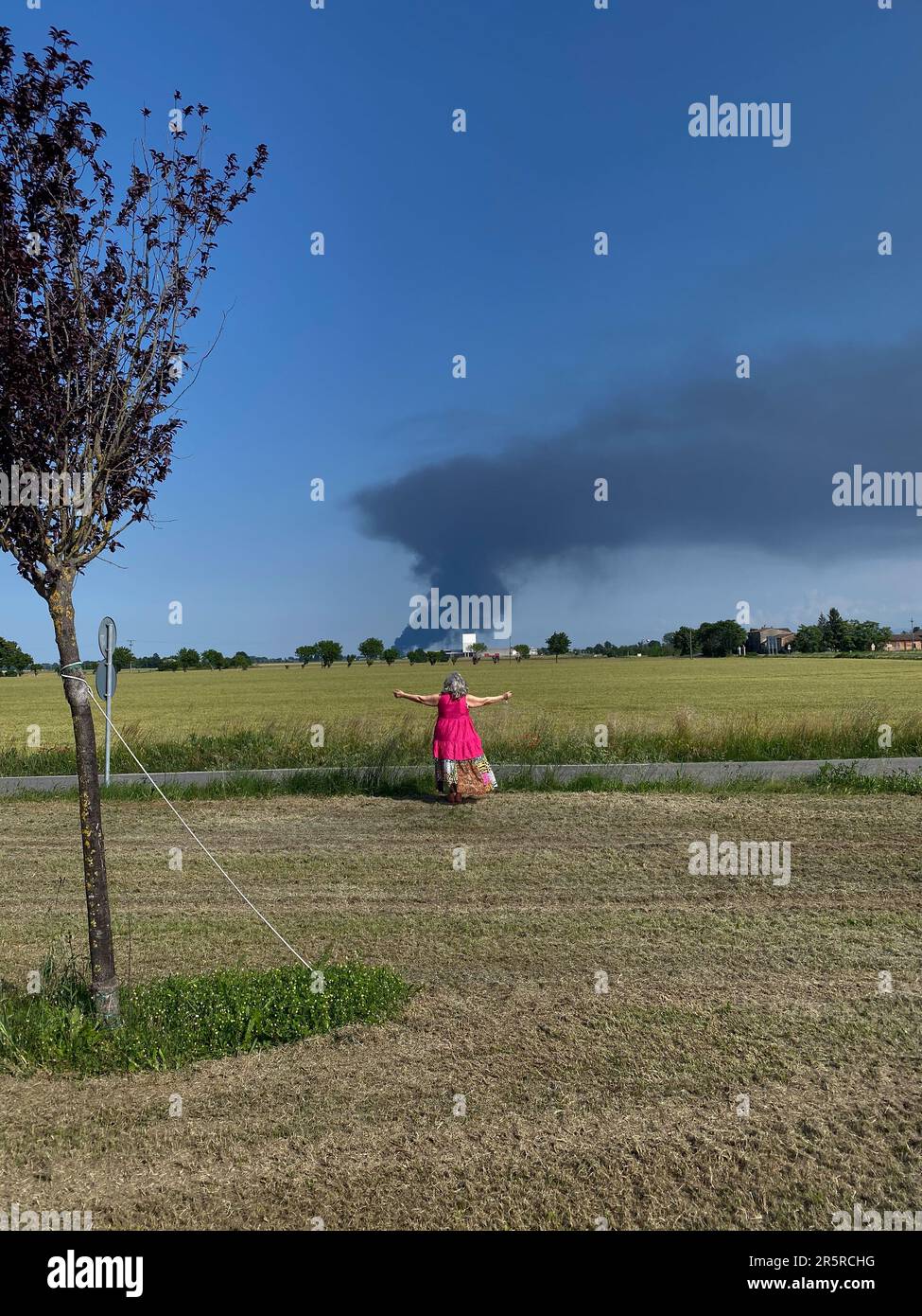 woman worries for giant black cloud from fire of plastic factory ...