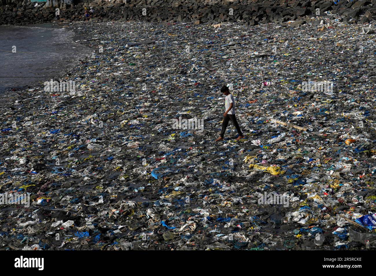 A boy walks on the plastic waste at the Badhwar Park beach on the ...