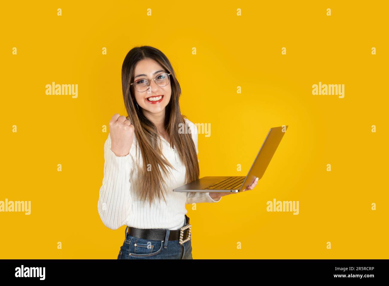 celebrating with winner gesture. Beautiful young brunette office worker ...