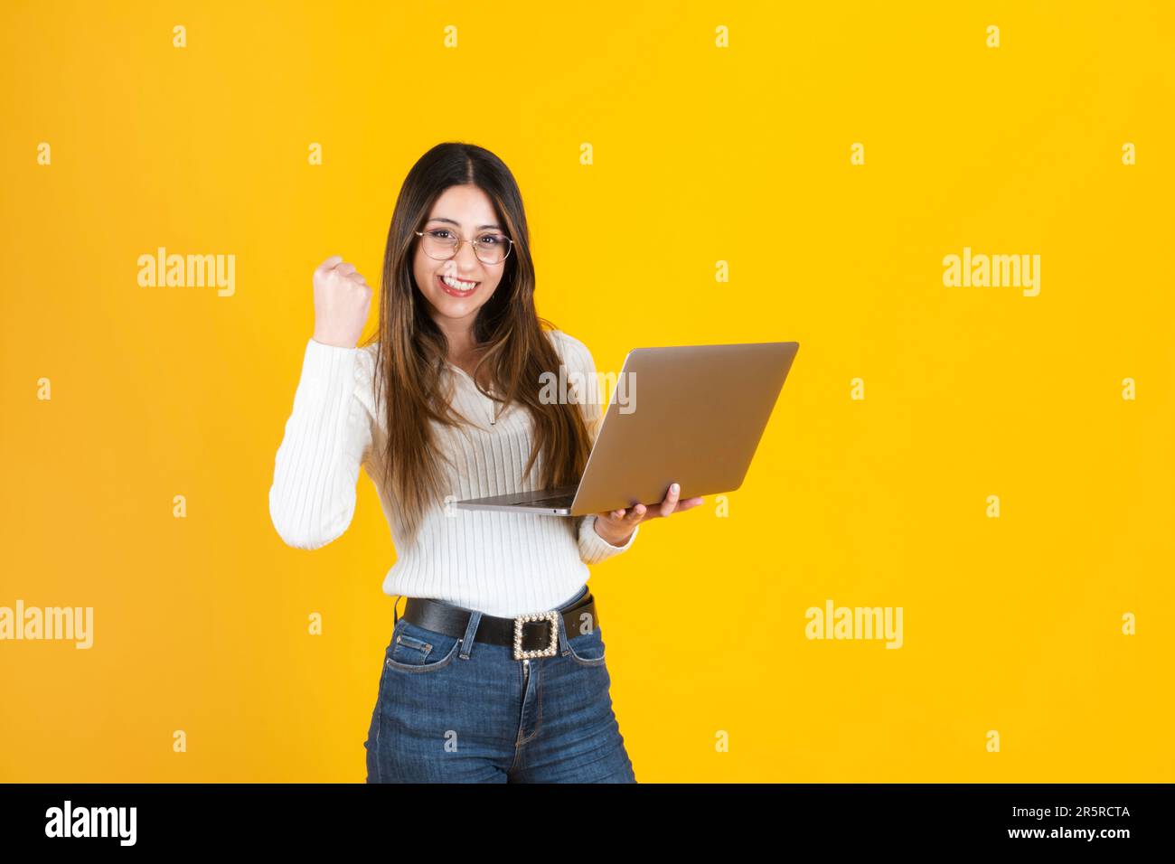 Holding laptop, winner gesture. Portrait of happy caucasian lady ...