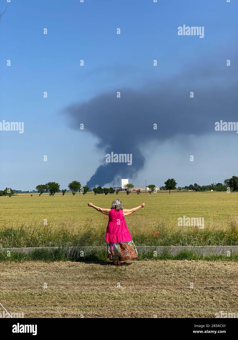 woman worries for giant black cloud from fire of plastic factory ...