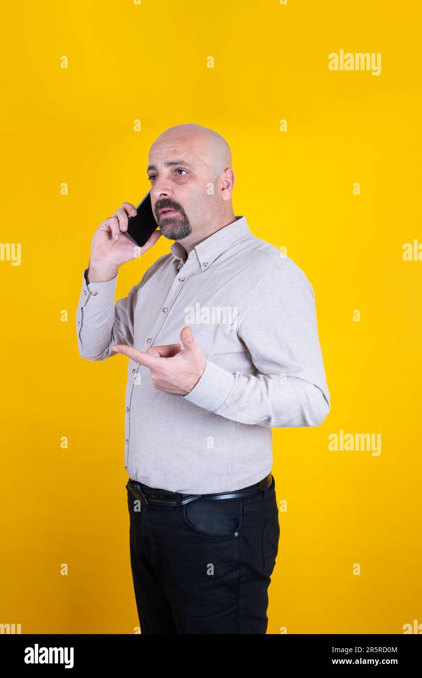Bald man talking on the phone. Communication concept idea. Speaking ...