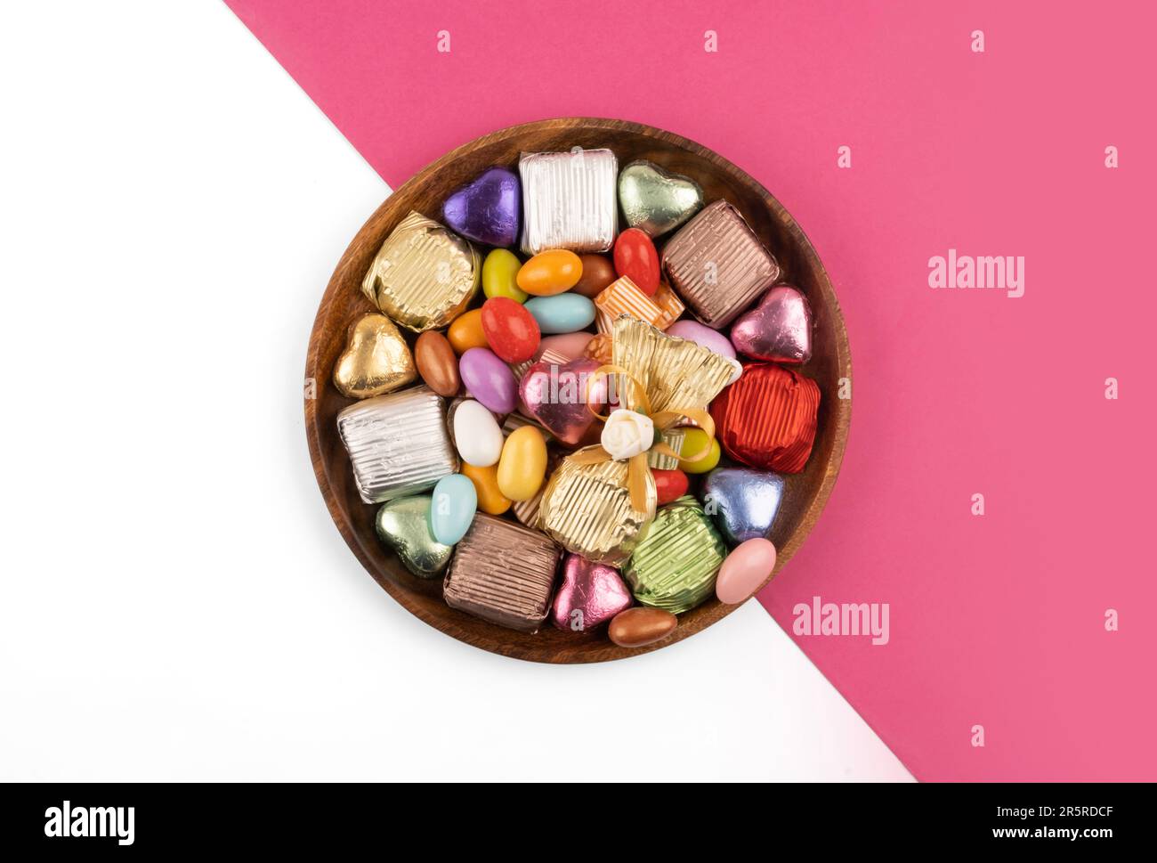 Top view plate of chocolate candies. Wrapped multicolored foil. Almond ...