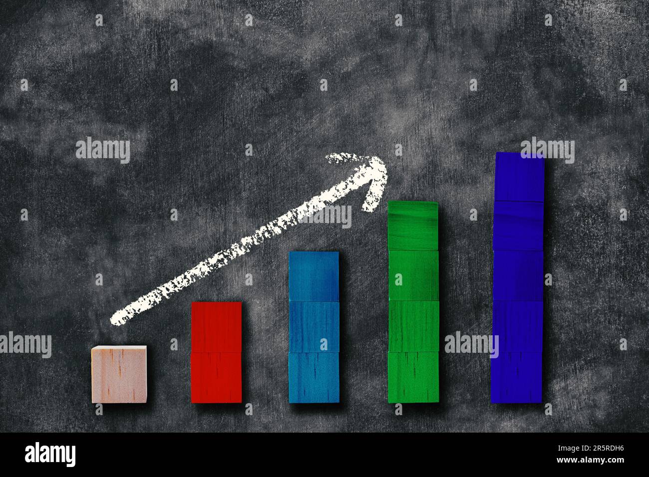 The colorful block forming a rising graph on a chalk background with an ...