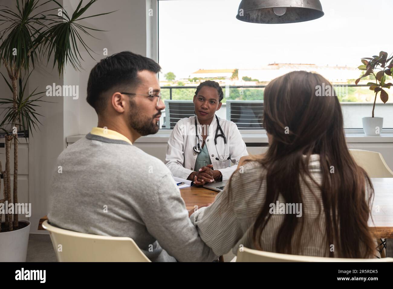 Woman doctor visits a young married couple in their home and gives ...