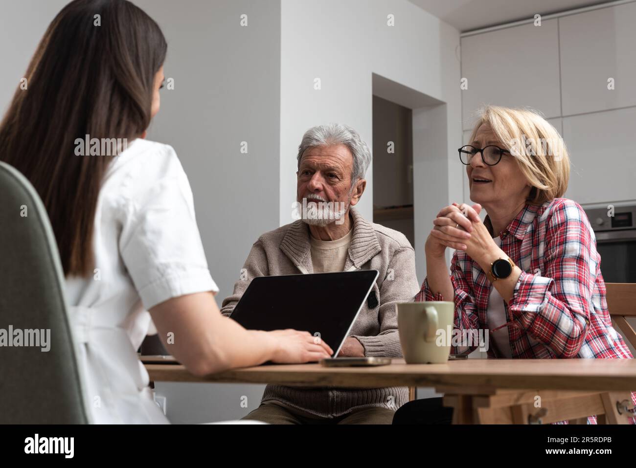 Female professional doctor consulting senior couple patient during ...