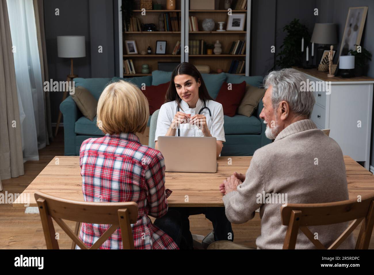 Female professional doctor consulting senior couple patient during ...