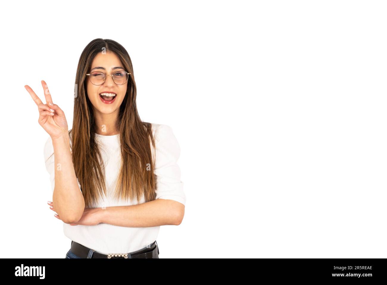 Gesturing v-sign with two fingers, portrait of beautiful happy girl ...