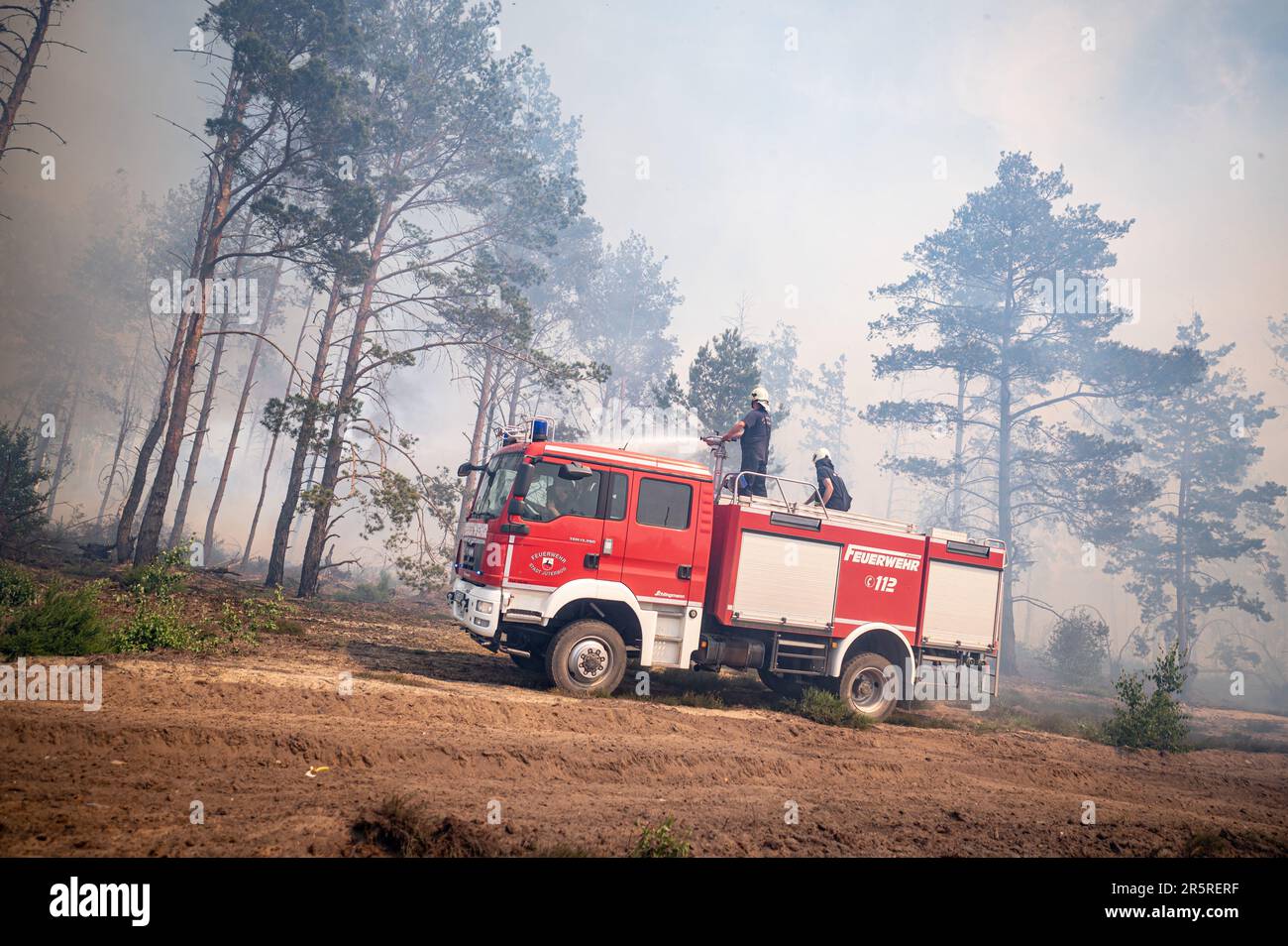 05 June 2023, Brandenburg, Jüterbog: Firefighters fight the fire in a ...