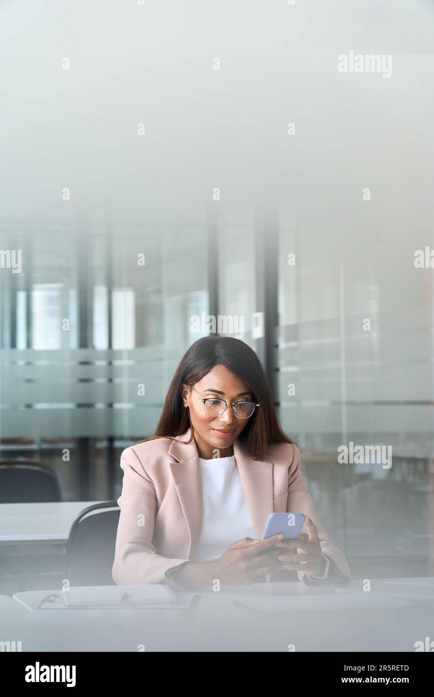 Business woman using mobile cell phone working at desk in office ...