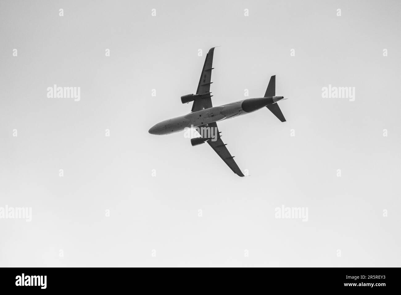 A low angle of an airplane in mid-flight soaring through the air in a ...