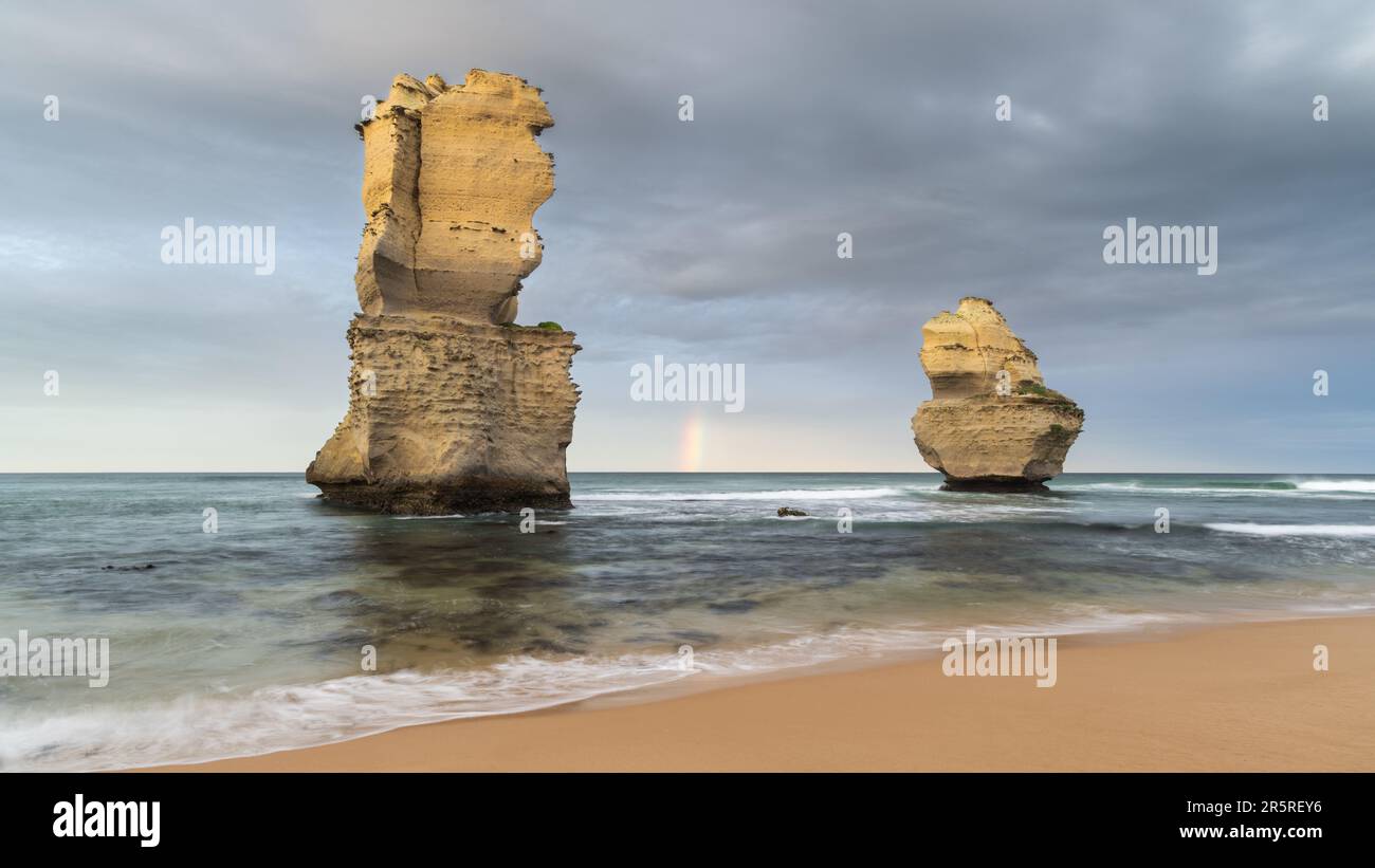 A picturesque beach landscape featuring three distinct rock formations ...