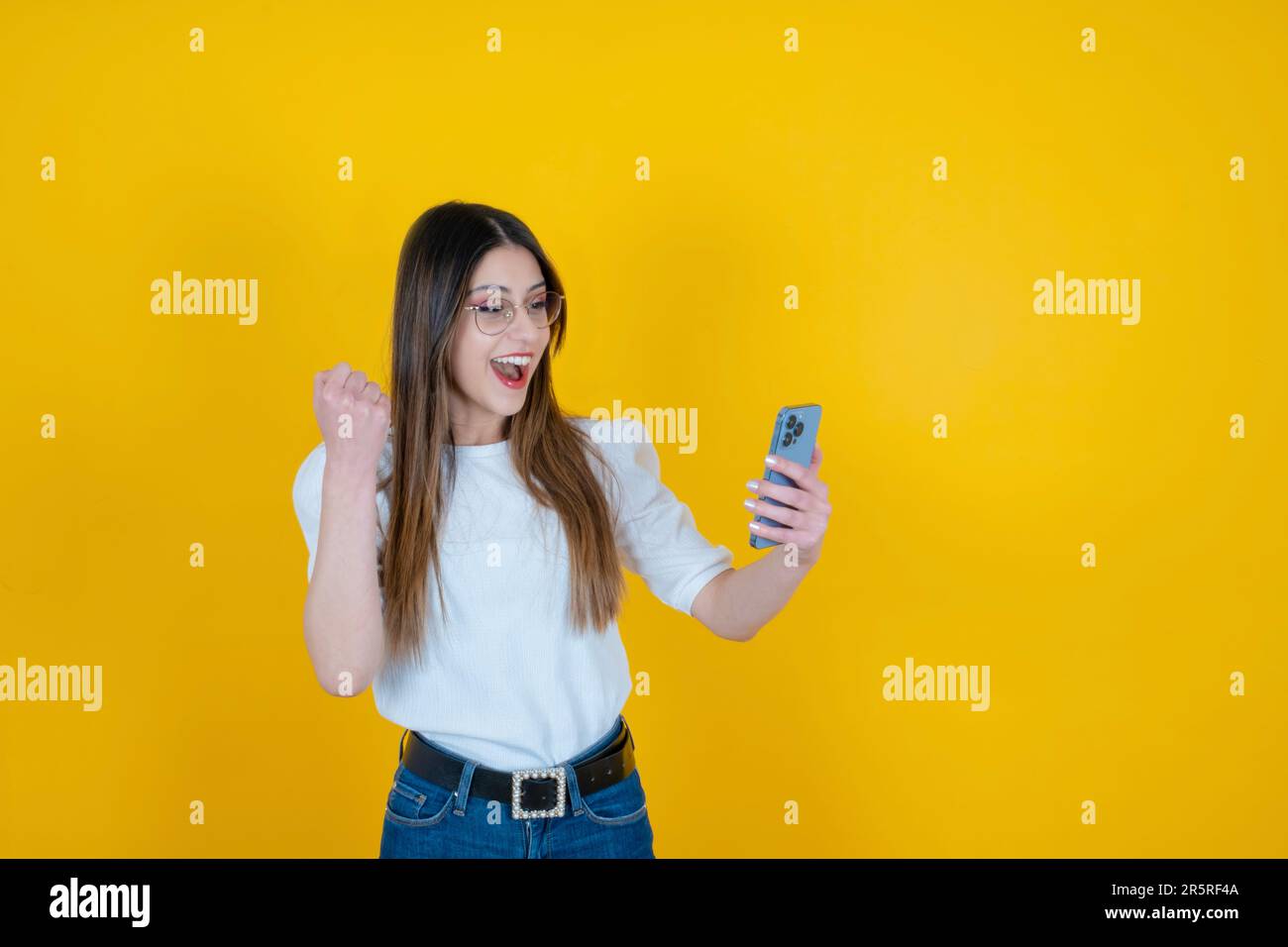Yes, i win! Portrait of young surprised woman using smartphone, making ...