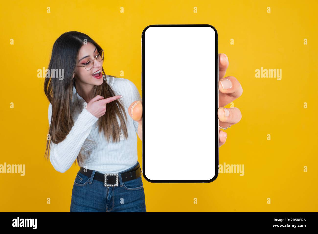 woman holding big blank cell phone. Millennial lady pointing finger ...