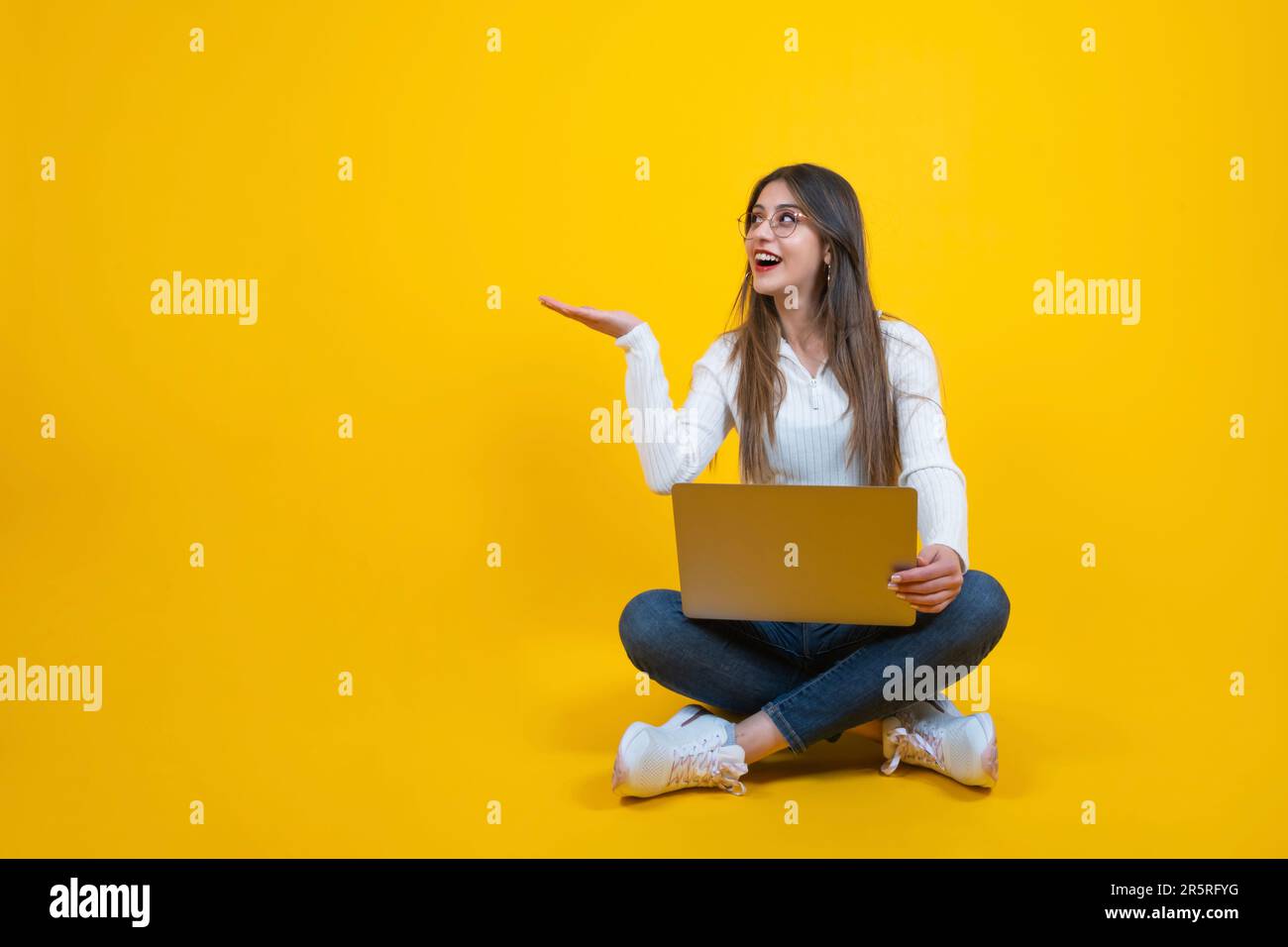Cheerful happy woman sitting floor demonstrating something. Looking ...
