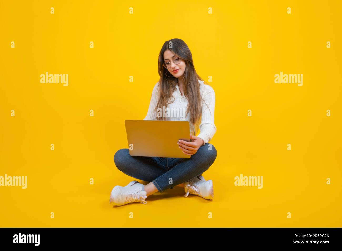 full body view woman sitting on the ground working on laptop. Young ...