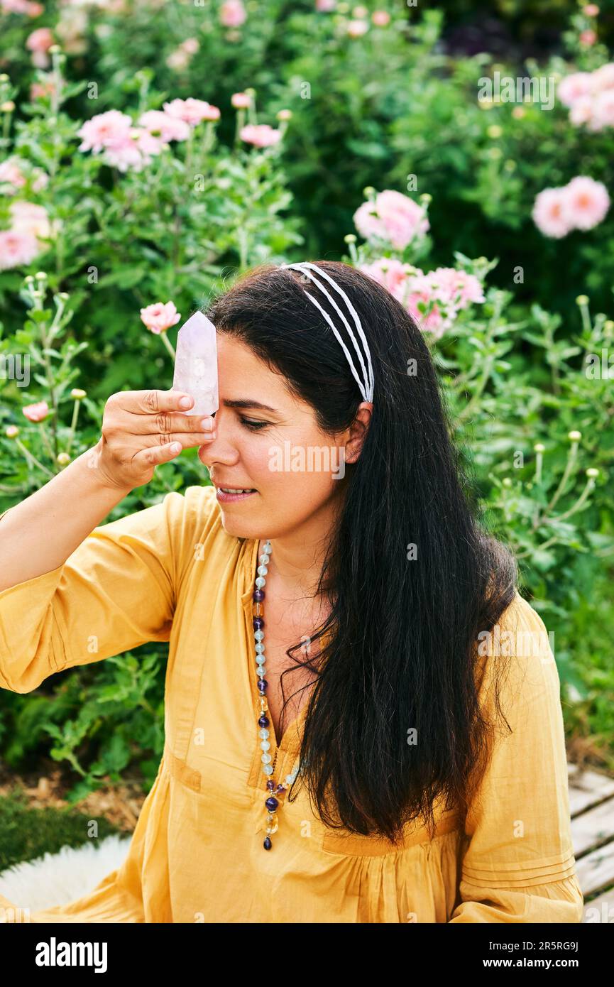 Woman healer holding natural mineral kunzite next to head Stock Photo ...