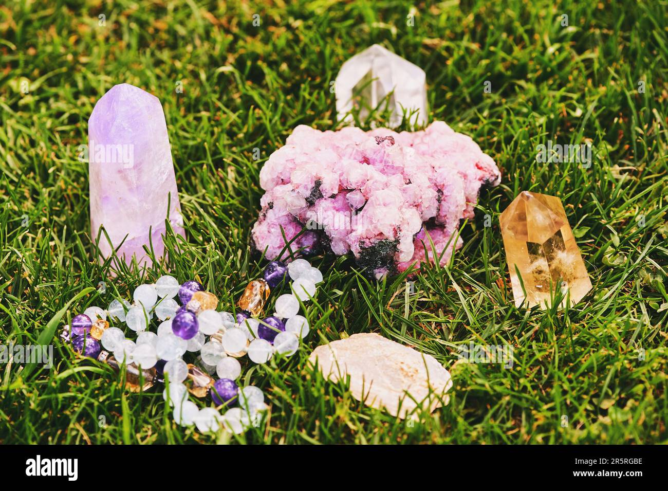 Collection of natural mineral crystals on green grass, esoteric healing ...
