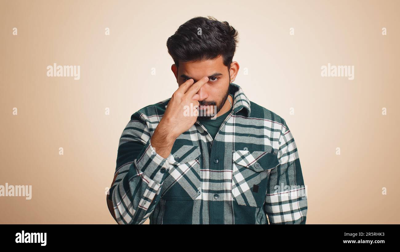 I am watching you. Young confident indian man pointing at his eyes and ...