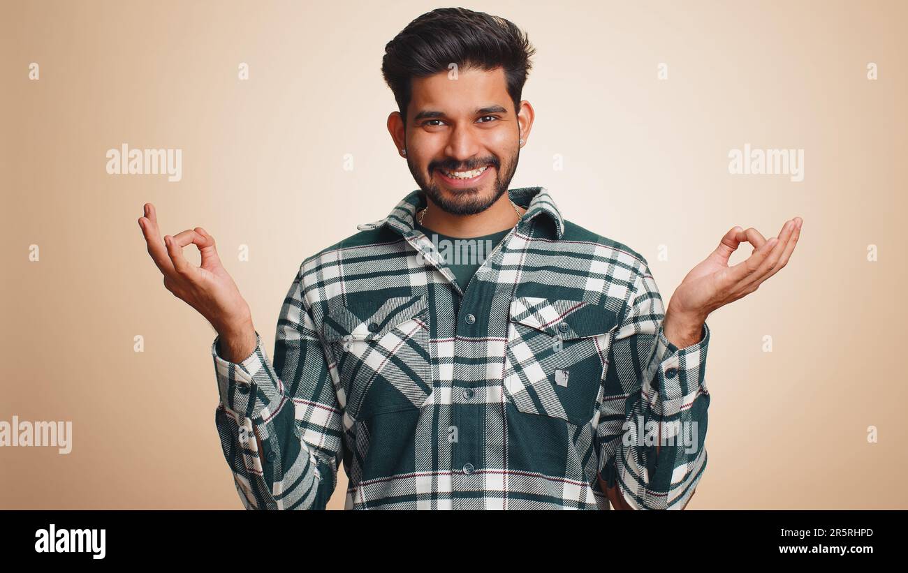 Keep calm down, relax, inner balance. Young indian man breathes deeply ...