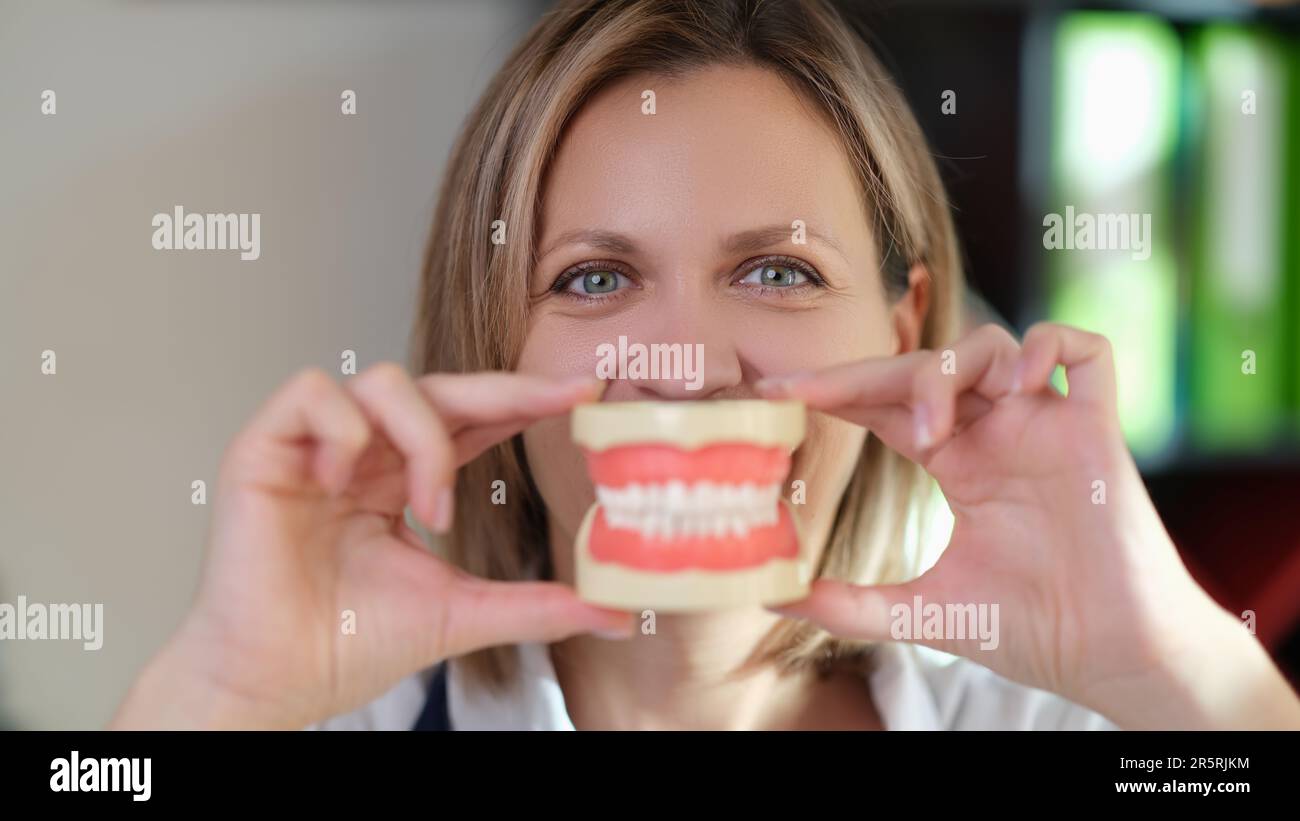 Positive dentist holds human jaws model by face in hospital Stock Photo ...