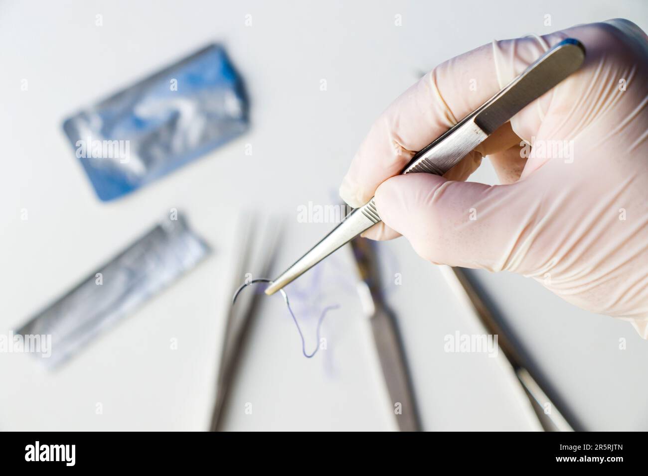 A doctor holding a suture with a surgical scalpel Stock Photo - Alamy
