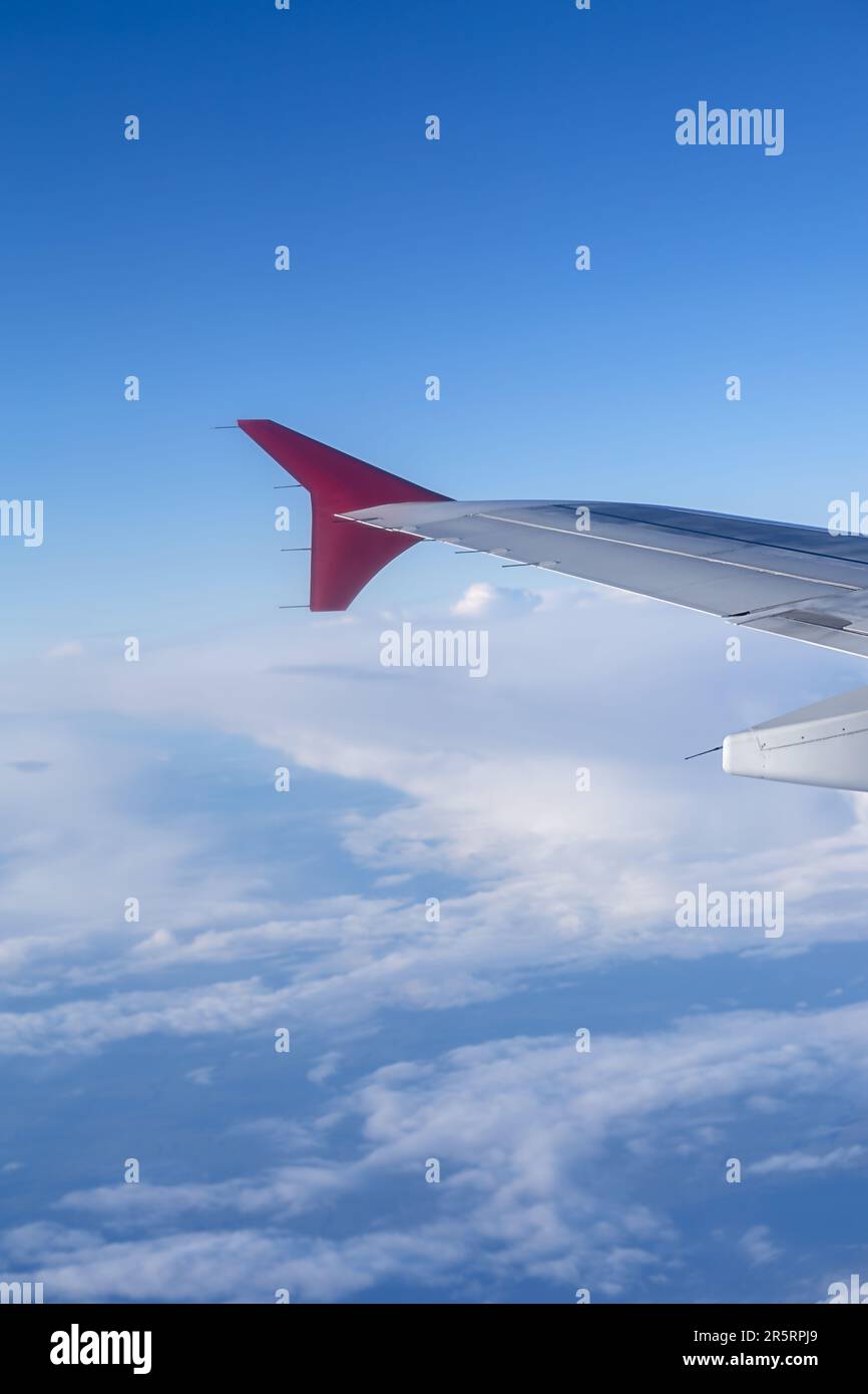 vertical photo the wing of a flying aircraft against the background of ...