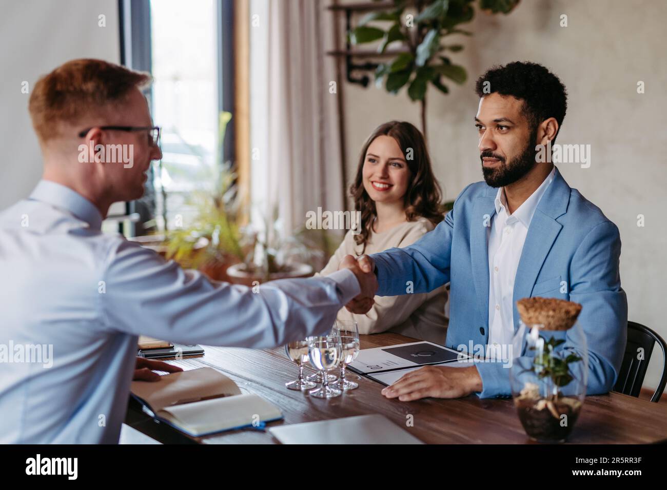 Multiethnic business partners shaking hands hi-res stock photography ...