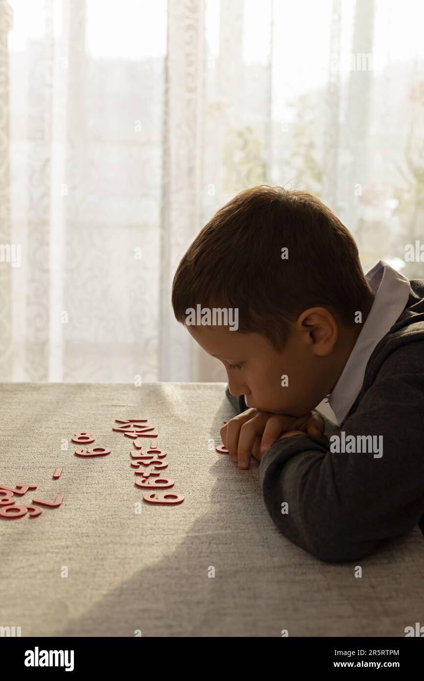 A boy learns to count at his desk using plastic numbers Stock Photo - Alamy